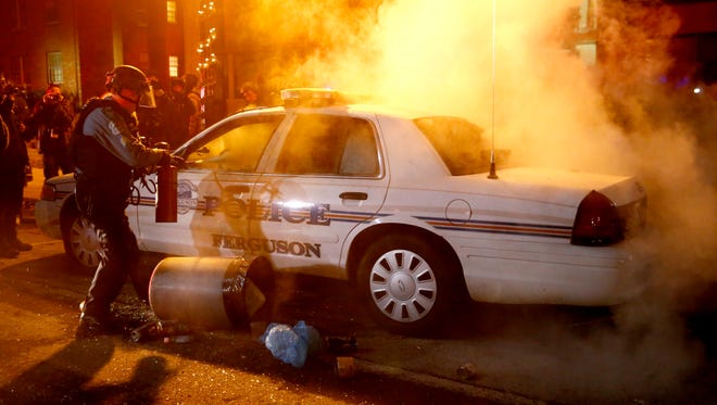 Police officers douse a police car fire after protesters set it ablaze ... Police officers douse a police car fire after protesters set it ablaze ...