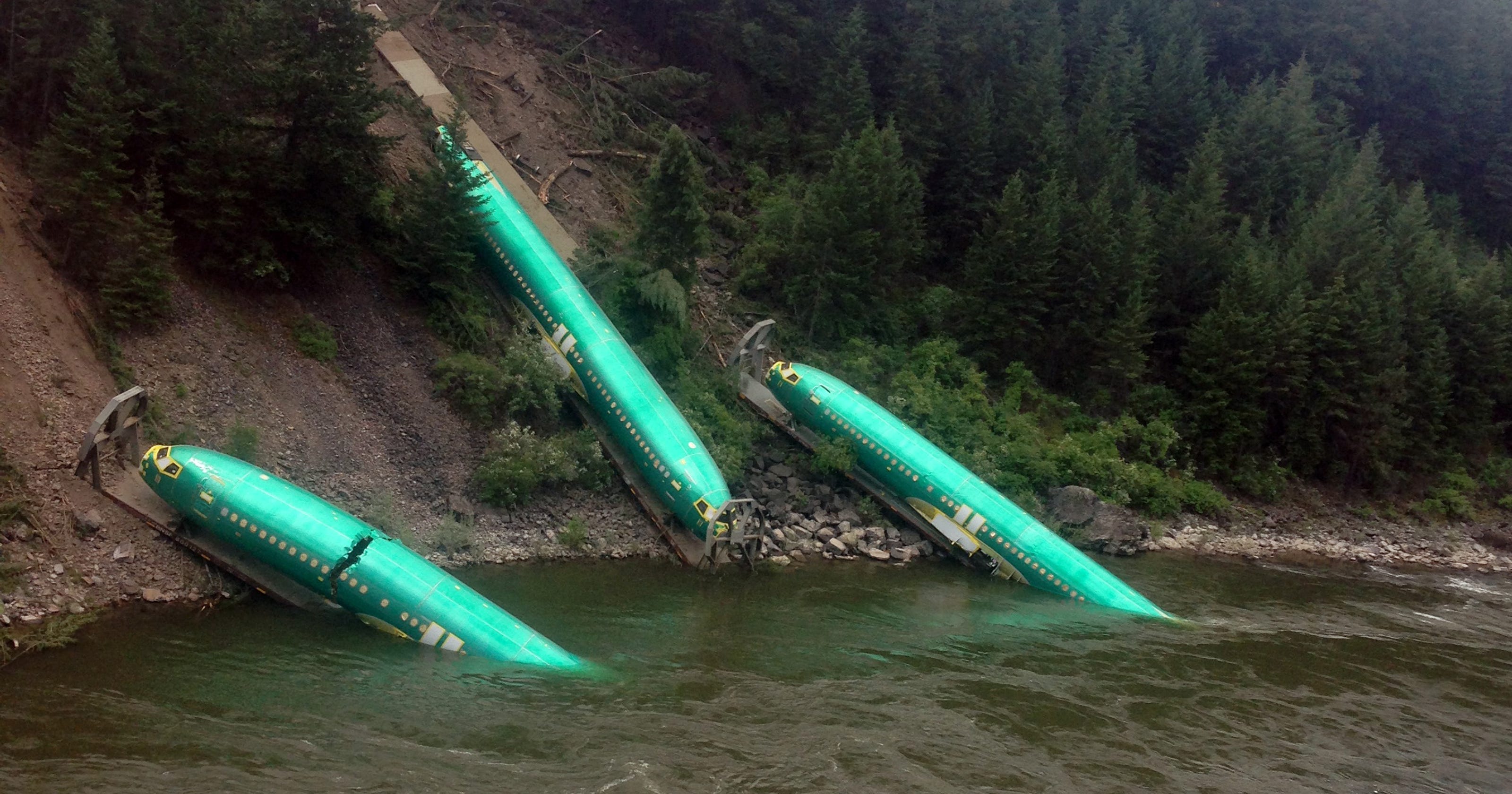 Train derailment spills Boeing 737 fuselages into river
