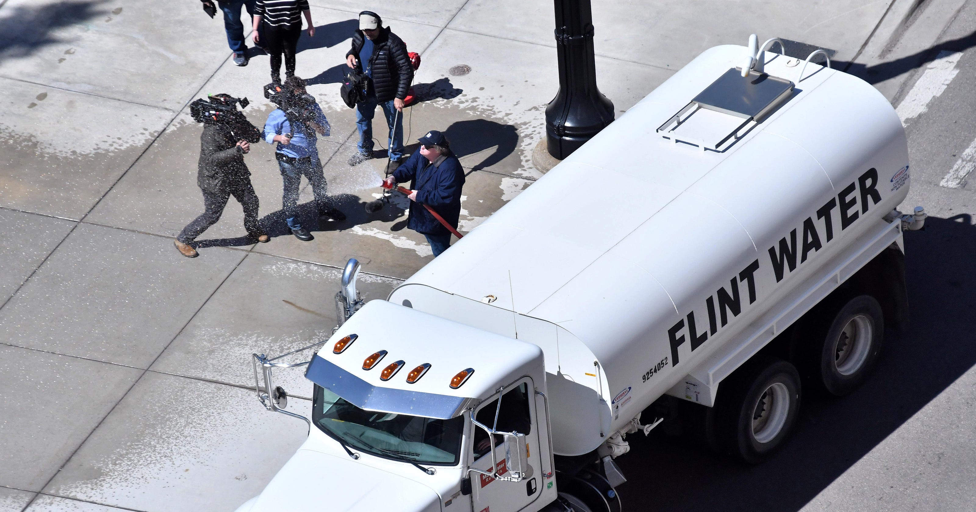 Michael Moore sprays ‘Flint water’ at Michigan Capitol