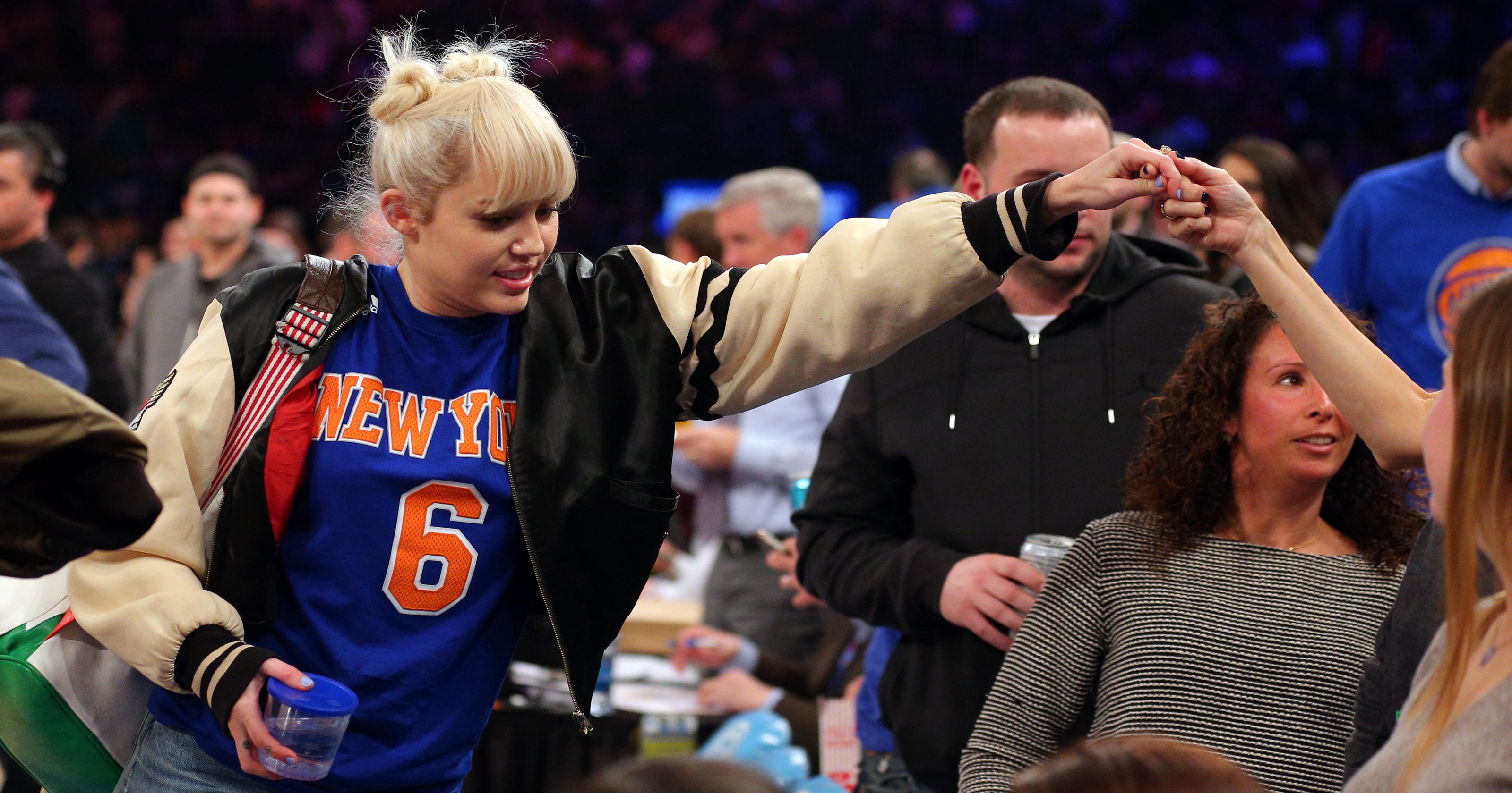 Miley Cyrus, sister, mom cheer at NBA game