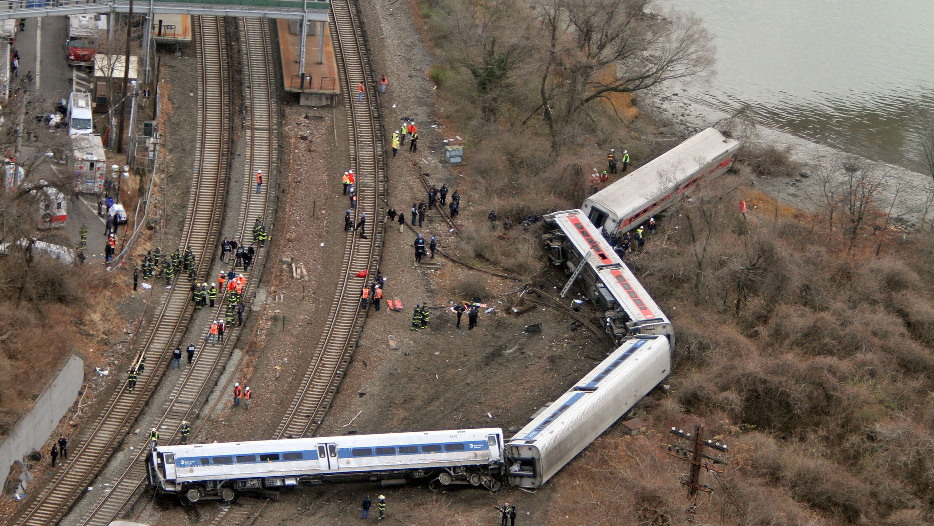 Emergency personnel work at the scene of a Metro-North train that ...