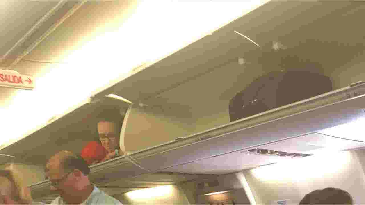 Southwest flight attendant climbs into overhead bin