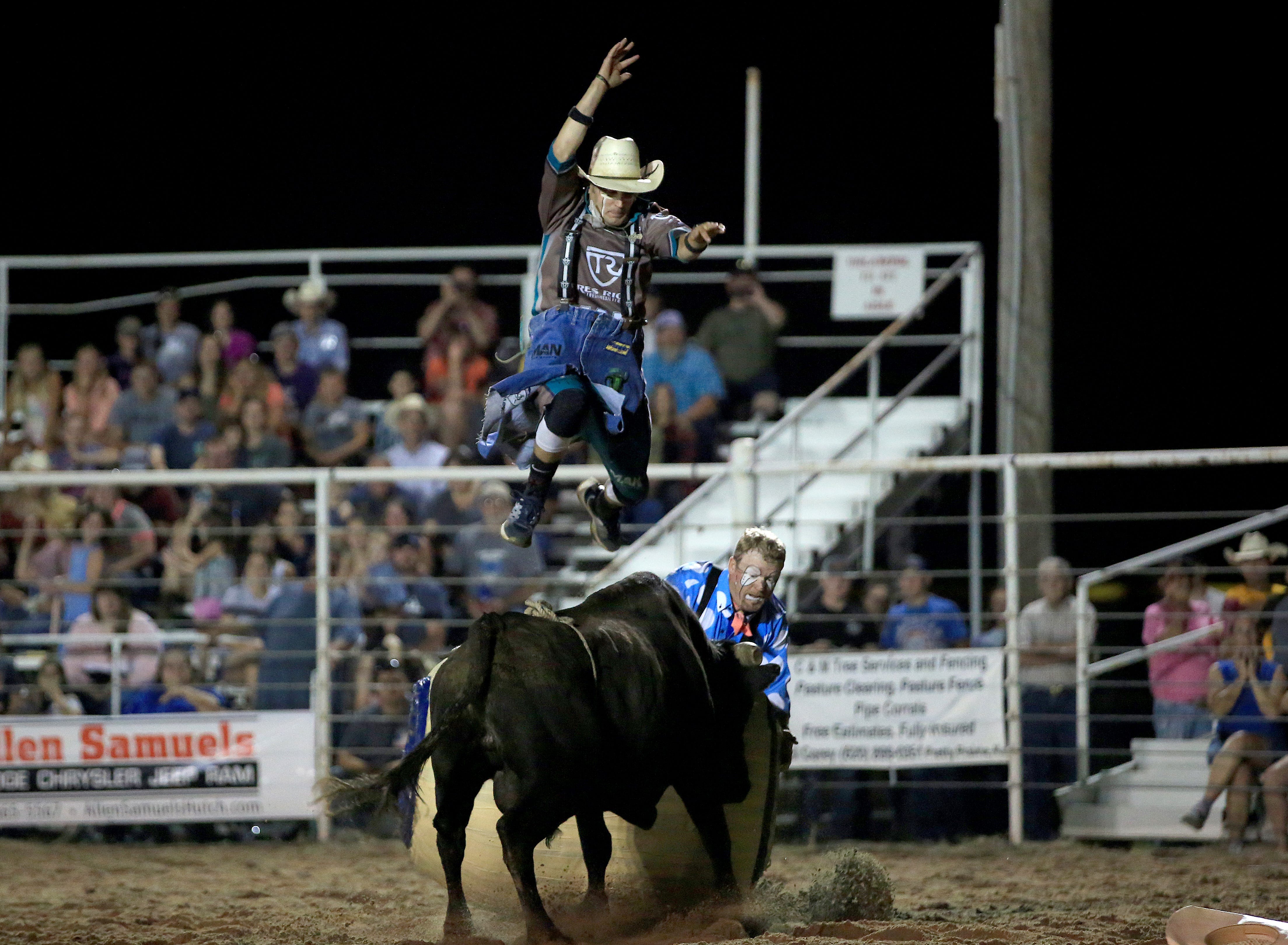 Kansas bullfighters work together to defend bull riders during rodeo