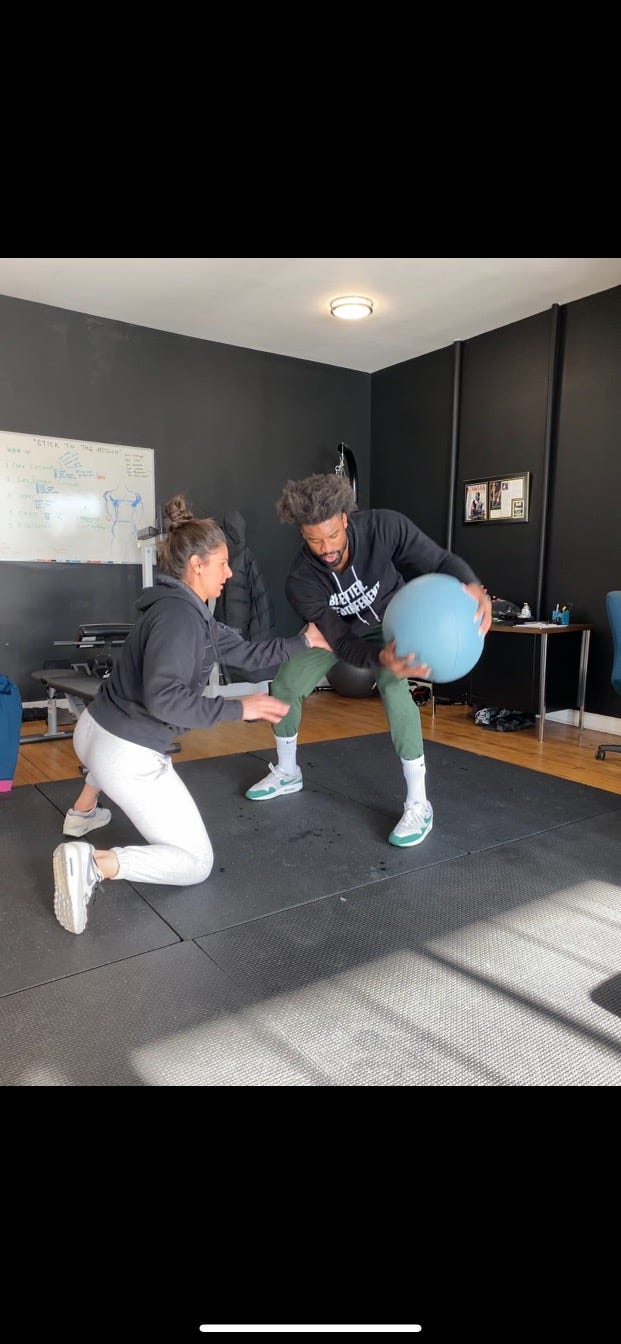 Wes Matthews helped by women's players Erin Monfre, Angela Rodriguez